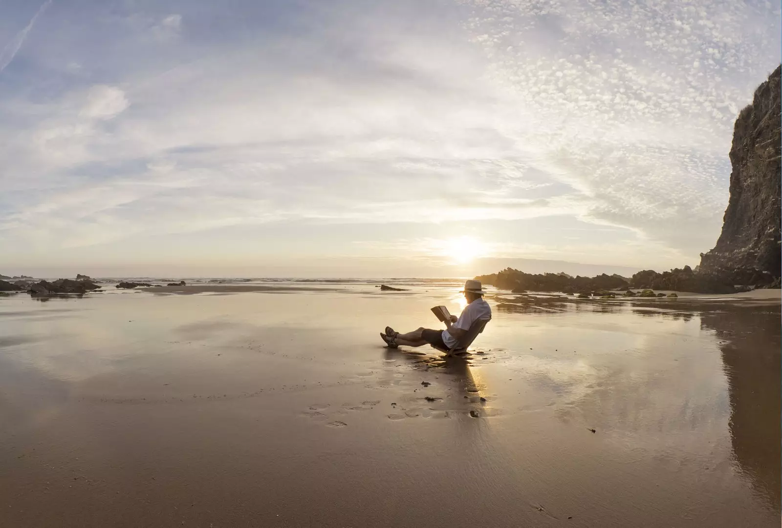 homem lendo na praia