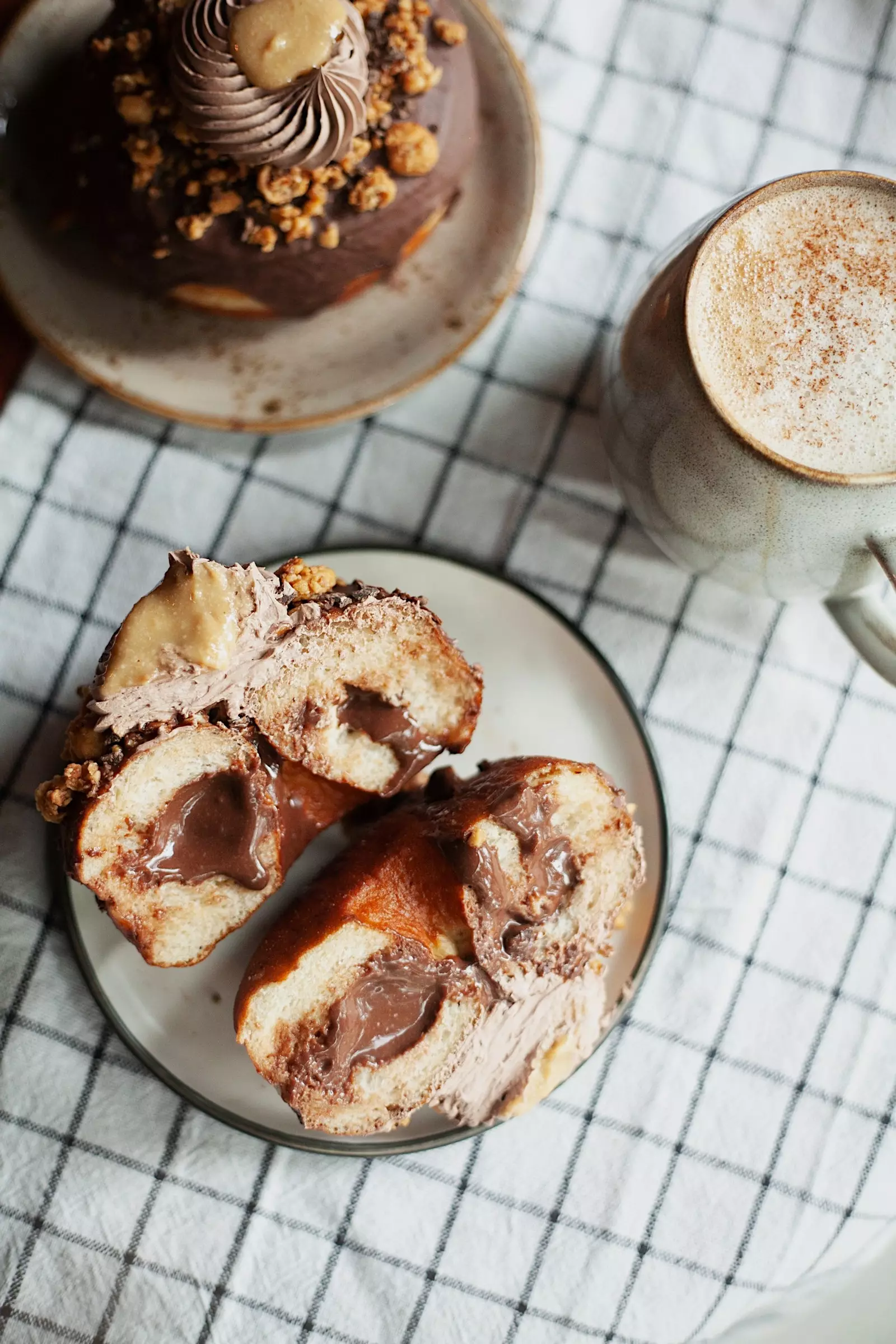 Donat berisi coklat bersebelahan dengan chai latte di Bite Me Café