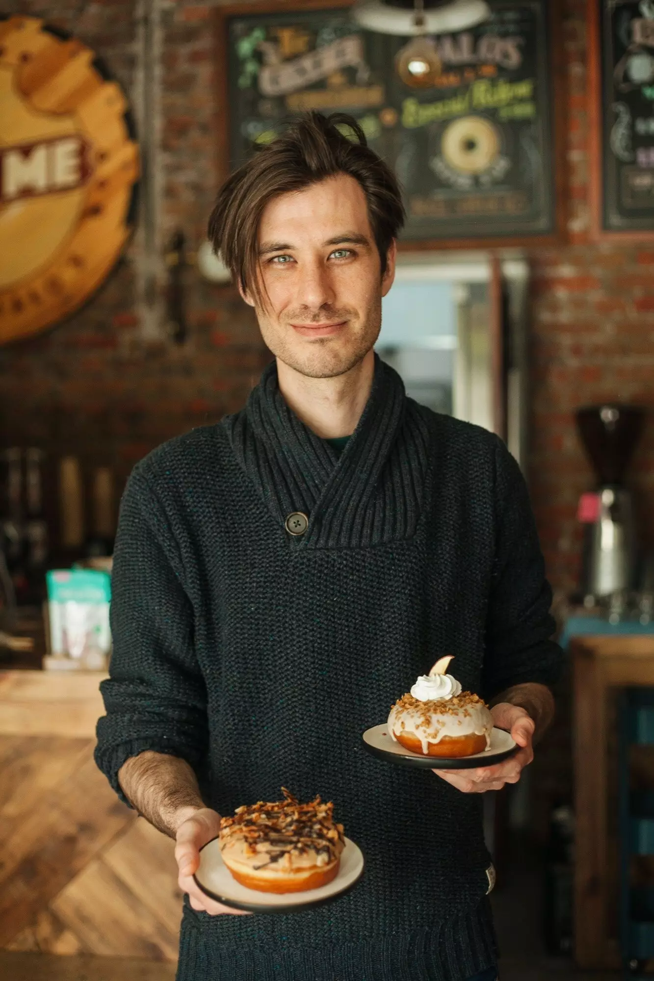 Majiteľ kaviarne Bite Me Café Joel s dvoma svojimi vegánskymi donutmi