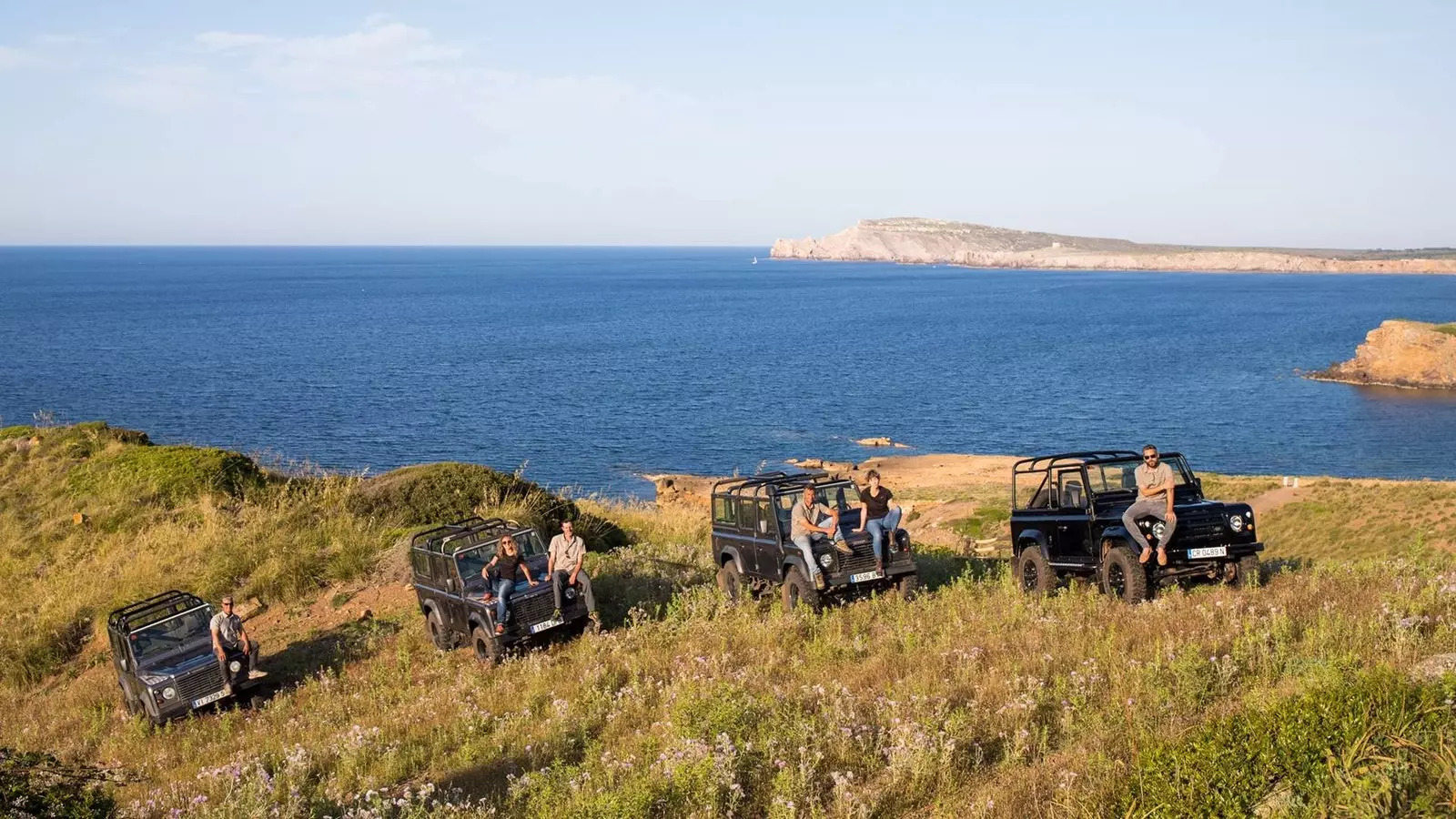 Four jeeps standing in front of the sea in Menorca.